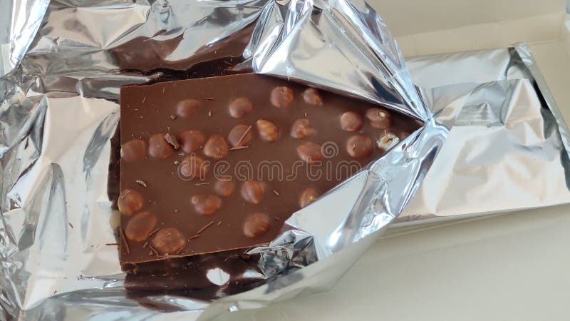 Chocolate with Hazelnuts in Foil and Packaging, Partially Opened Stock ...