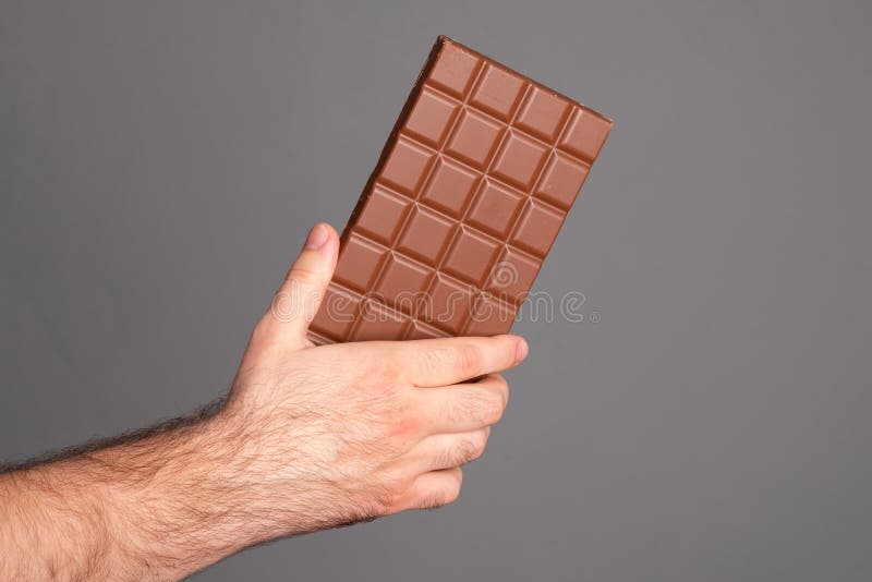 Chocolate in a man`s hand. stock image. Image of hold - 184359083