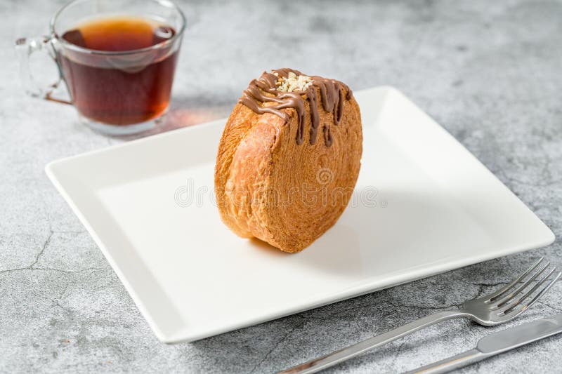 Chocolate New York Roll or Round Croissant with Tea on Stone Table ...