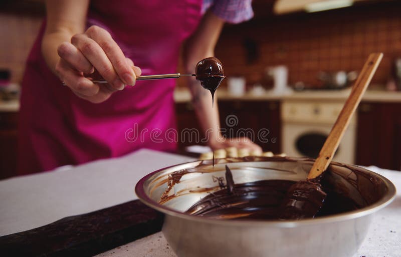 Chocolate Pastry Chef Dipping Pastry Fork with Candy into Melted ...