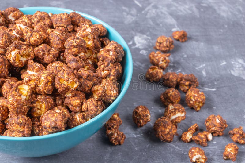 Chocolate Popcorn in a Blue Cup on a Dark Background. Sprinkled Popcorn ...