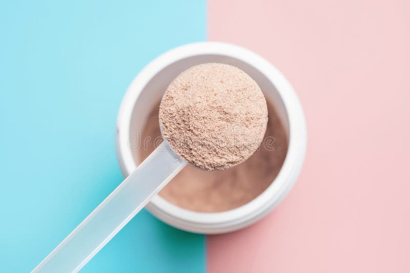 Chocolate Protein Powder in Scoop Against Plastic Jar on Pink and Blue ...