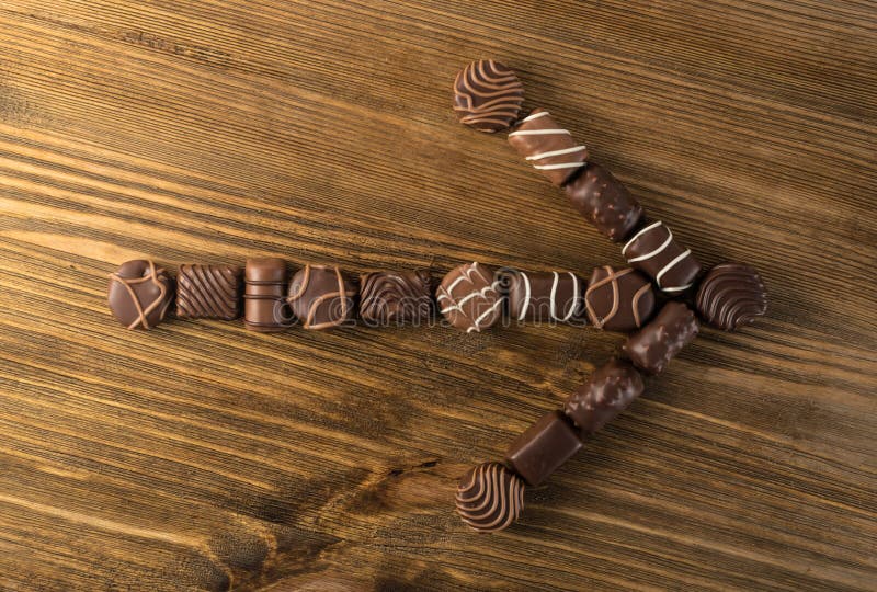 Chocolate Sweets Arrow on Old Wooden Background Stock Photo - Image of ...
