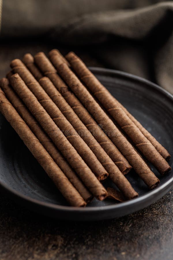 Chocolate Wafer Rolls on Plate on Dark Table Stock Photo - Image of ...