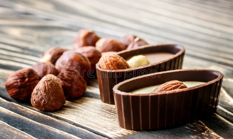 Chocolates and Hazelnuts on an Wooden Table Stock Photo - Image of ...