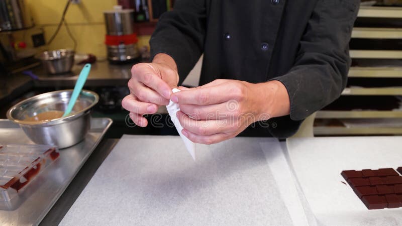 Chocolatier Making a Piping Bag with Parchment Paper Stock Video ...