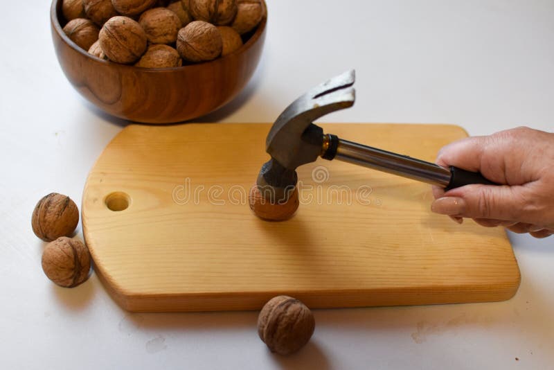 Chop Walnuts with a Hammer on a Cutting Board. Strong Natural Walnuts ...