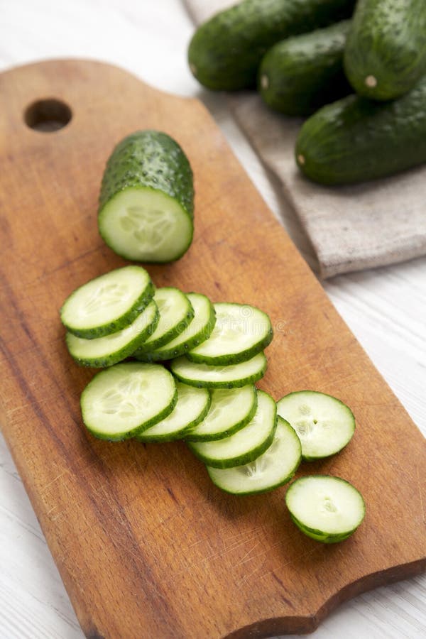 Chopped Mini Baby Cucumbers on a Rustic Wooden Board on a White Wooden ...