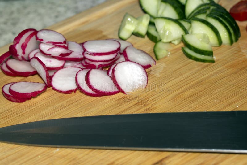 Chopped Up Sliced Cucumber and Radish on a Chopping Board in a Kitchen ...