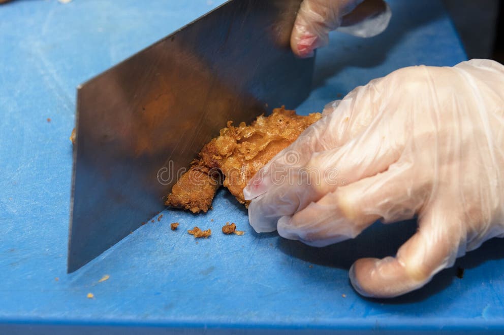 Chopping Battered Chicken on a Blue Board with a Kitchen Machete Stock ...
