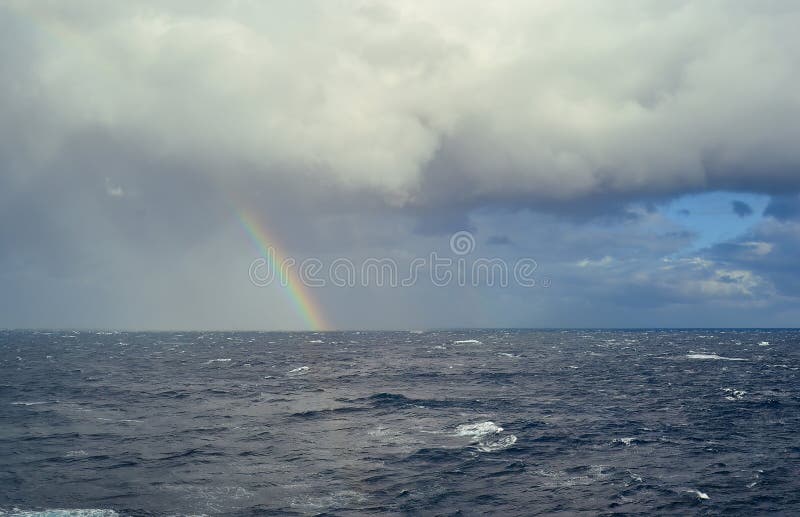Choppy Ocean with Partial Rainbow and Cloudy Sky at Open Sea Stock ...