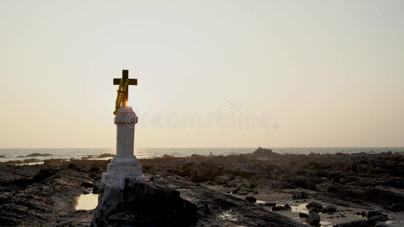 The Christian Cross on the Rocks by the Sea Against the Sunset. Stock ...