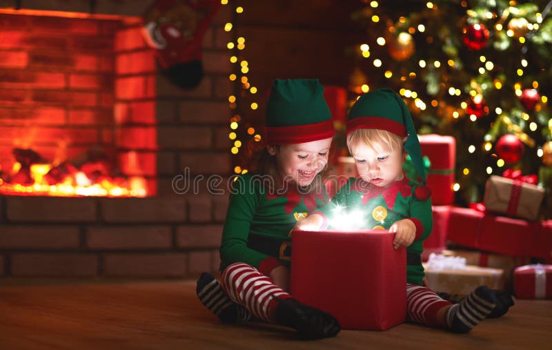 Christmas. Elves with a Magic Gift Near Christmas Tree and Fireplace ...