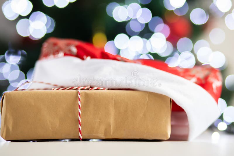 Christmas Parcel,christmas Gift in Santa Hat Under Christmas Tree Stock ...