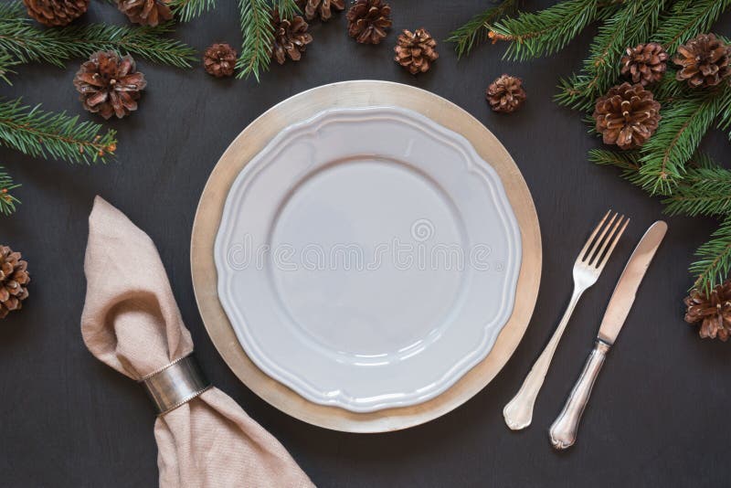 Christmas Table Setting with Silverware and Dark Evergreen Decor. Top ...