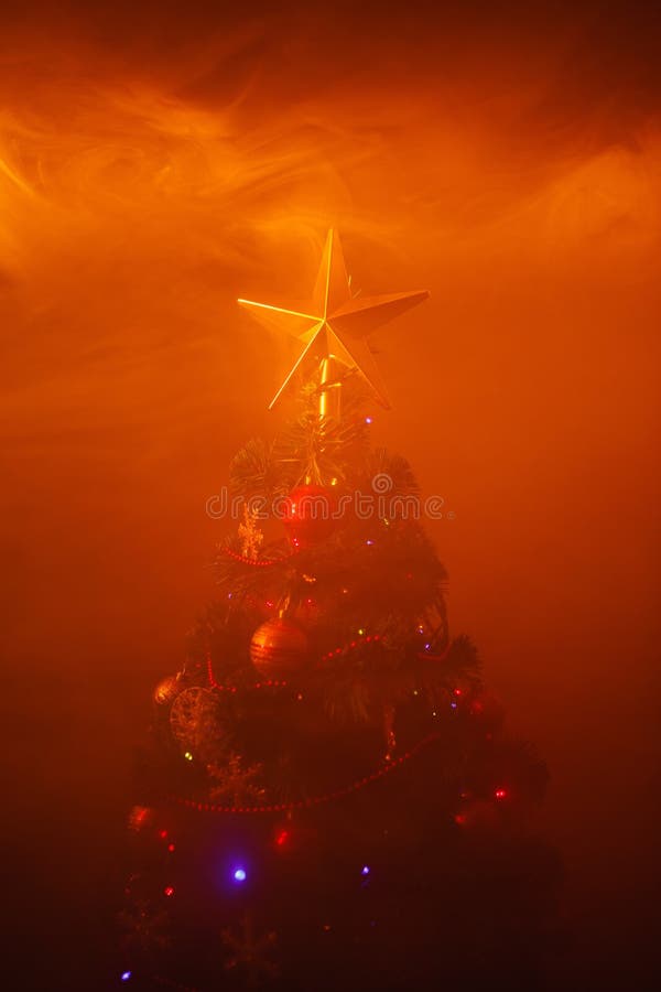 Christmas Tree with Festive Lights, Orange Background with Smoke Stock ...