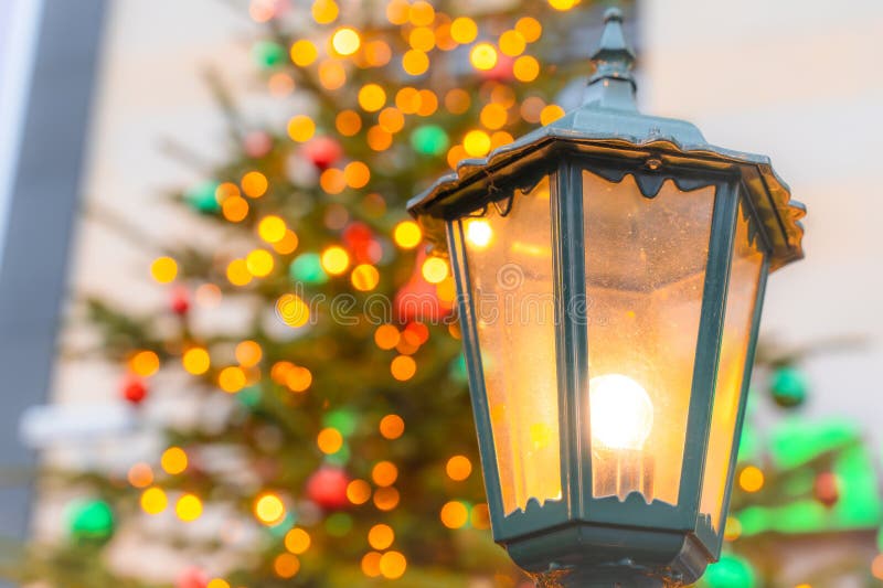 A Christmas Tree with Lights and a Green Lantern with a Light on it ...
