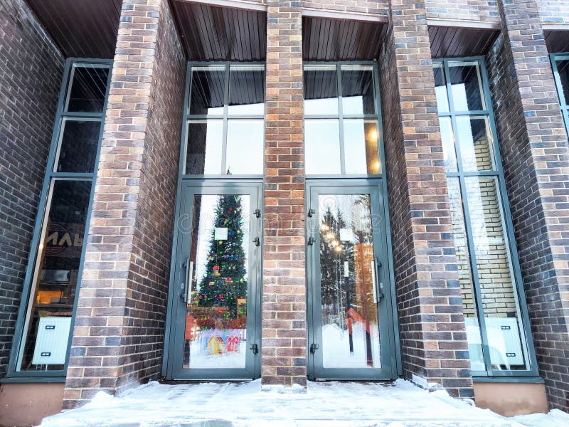 Christmas Tree through Window of Snow Covered Storefront with Brick ...