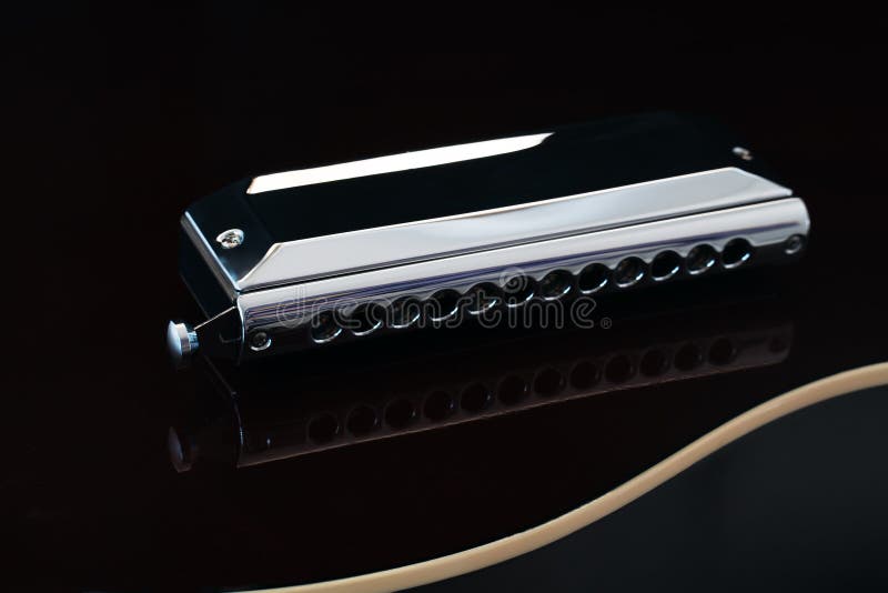 Chromatic Harmonica Lying on Back of Acoustic Guitar Stock Image ...