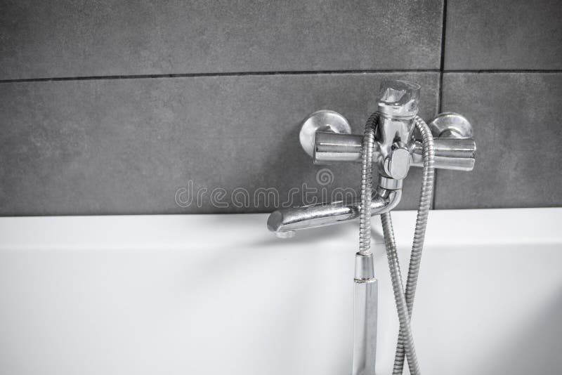 Chrome Tap with a Shower with a White Bath in a Bathroom with a Grey ...