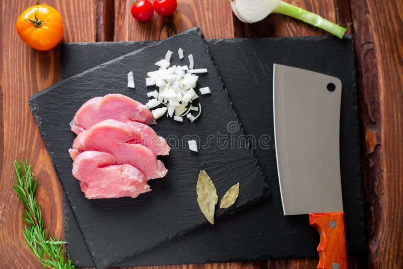 Chunks of Sliced Raw Turkey Meat, Chopped Onions, on a Black Slate ...