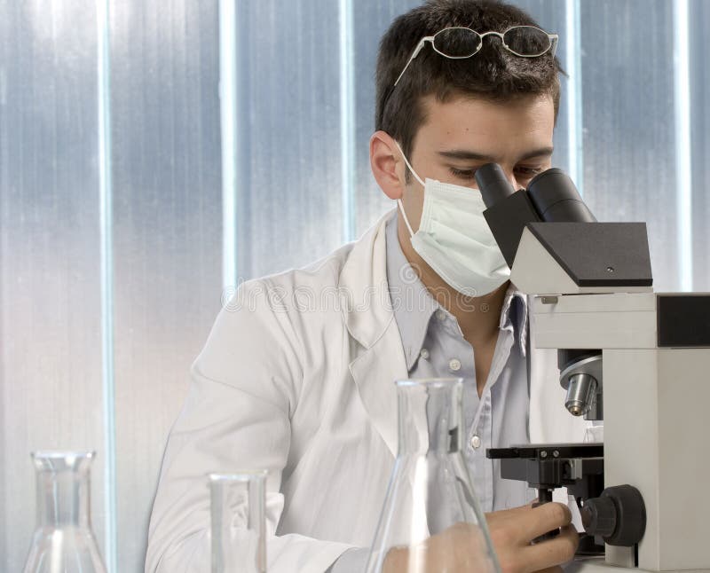 Científico Joven Que Mira Dentro De Un Microscopio Imagen de archivo ...