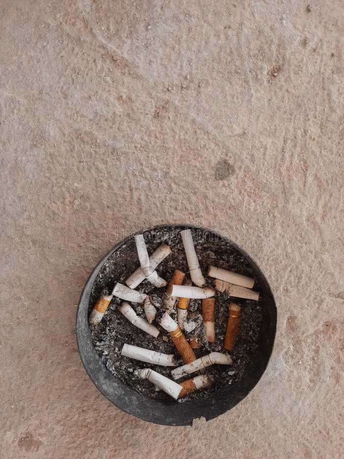 Cigarette Butts in an Iron Ashtray Placed on a Concrete Floor Stock ...