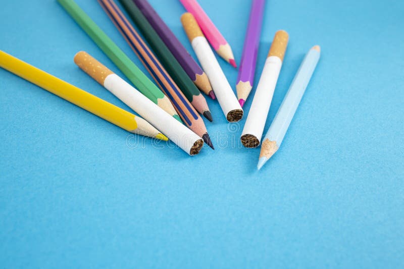 Cigarettes between Colored Crayons on Blue Paper Backdrop Stock Image ...