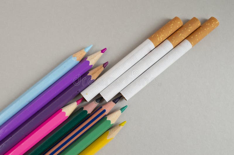 Cigarettes between Colored Crayons on Gray Paper Backdrop Stock Image ...