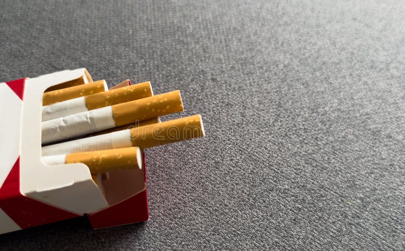Cigarettes Lined Up in Open Pack on White Surface Stock Image - Image ...