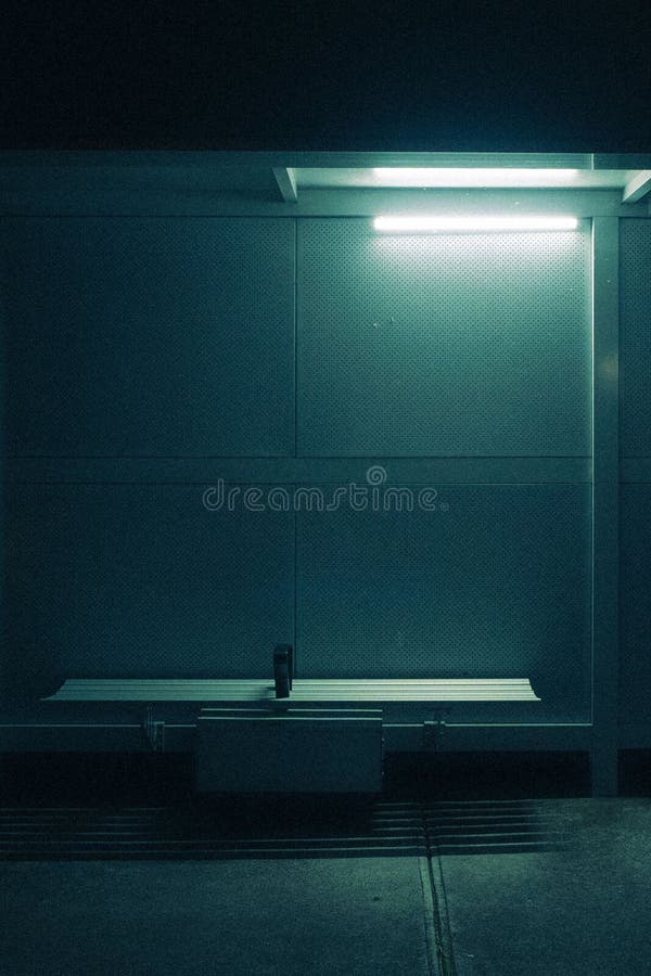 Cinematic Vertical Shot of an Empty Bus Stop at Night with a Light on ...