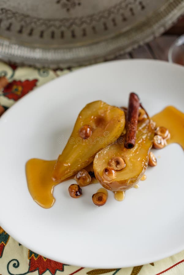Cinnamon Poached Pears with Caramel Sauce and Hazelnuts Stock Photo ...