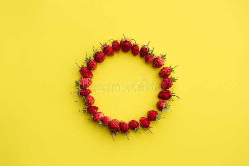 Circle of Red Wild Strawberry Berries on a Yellow Background. Copy ...