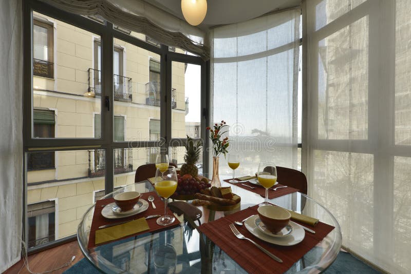 Circular Glass Dining Table with Fresh Fruit and Orange Juice with a ...