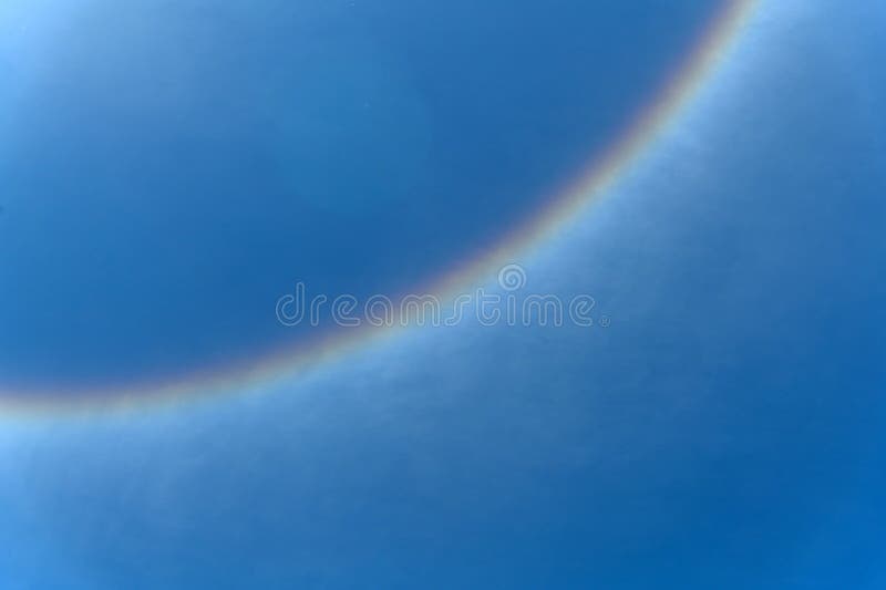 Circular Rainbow Surround the Sun on Blue Sky with Clouds. Sun Haloâ ...