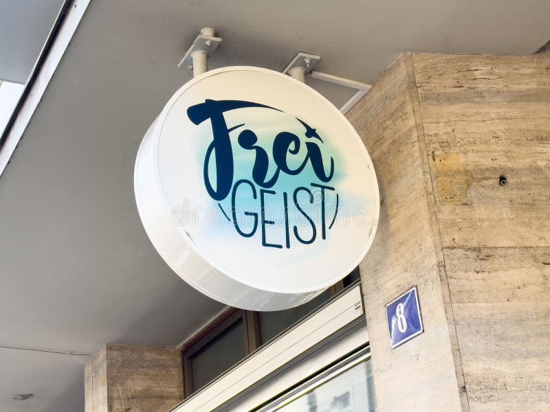 Circular Storefront Sign with Blue Free Spirit Text on Building Facade ...