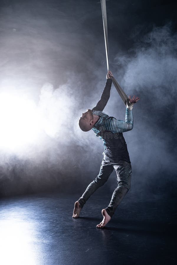 Circus Artist on the Aerial Straps with Costume on the Black and Smoked ... Circus Artist on the Aerial Straps with Costume on the Black and Smoked ...