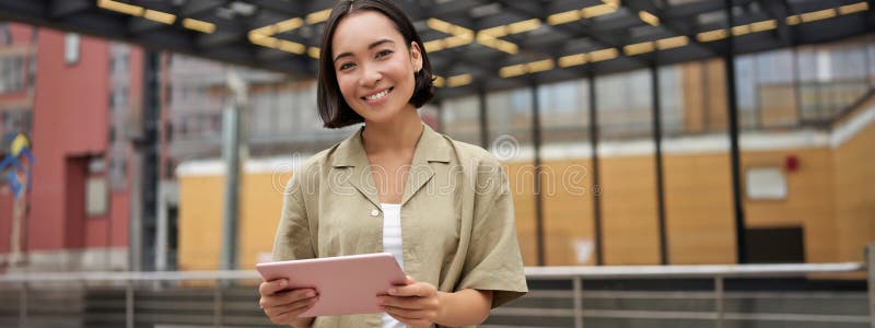 City Girl Standing with Tablet on Street, Using Application, Smiling at ...