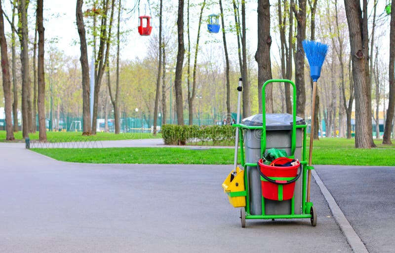City Park Cleaning Background with Wheeled Bin and Broom on the Flowers ...