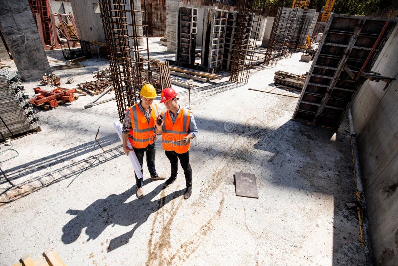 Civil Engineer and Architect Dressed in Orange Work Vests and Hard Bats ...