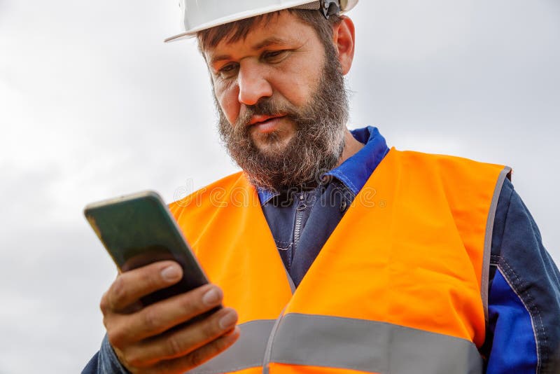 A Civil Engineer Looks at a Mobile Phone. a Bearded Man is Looking for ...