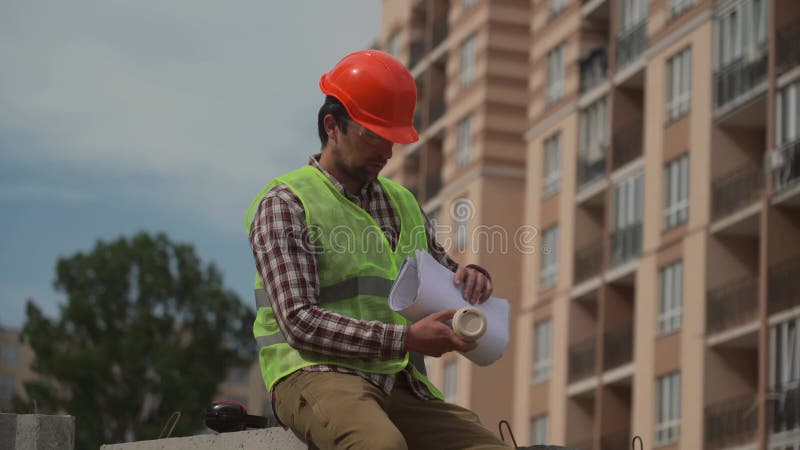 Civil Engineer Resting on His Lunch Break at Construction Site Drinking ...