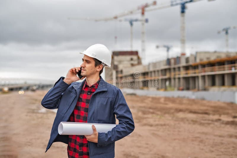 Civil Engineer in a White Helmet with Documents in His Hands Talking on ...