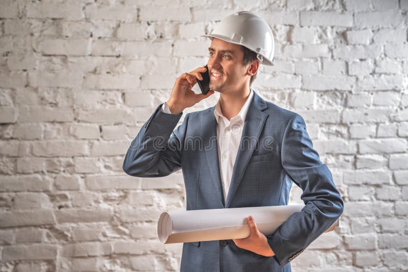 Civil Engineer in a White Helmet with Documents in His Hands Talking on ...