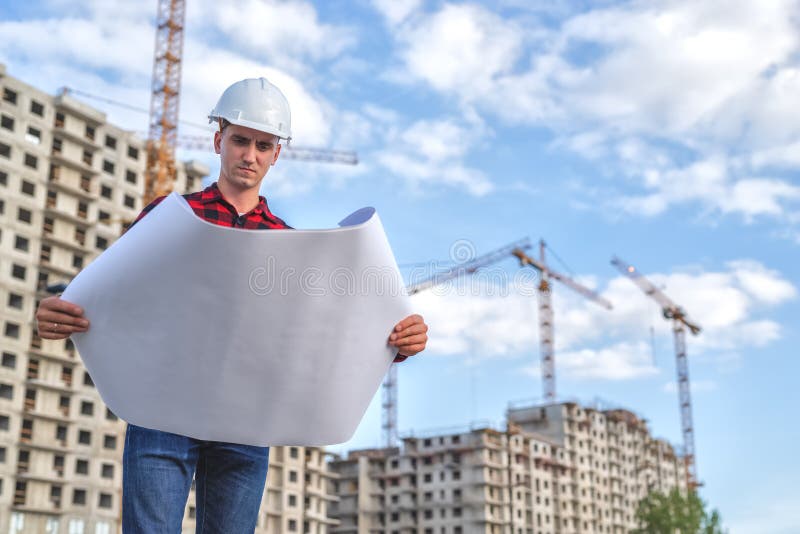Civil Engineer in a White Helmet Looking Documents on the Background of ...