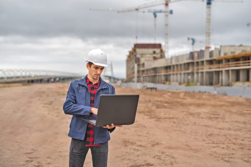 Civil Engineer in a White Helmet Looking Documents on the Background of ...