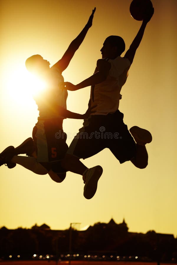 Clash of the Titans. Two Basketball Players Playing at Sunset. Stock ...