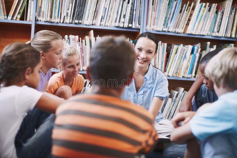 Class in the Library. a Pretty Teacher Sitting with Her Excited ...
