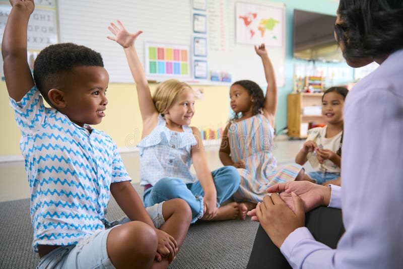 Class of Primary or Elementary School Students Raising Hands To Answer ...