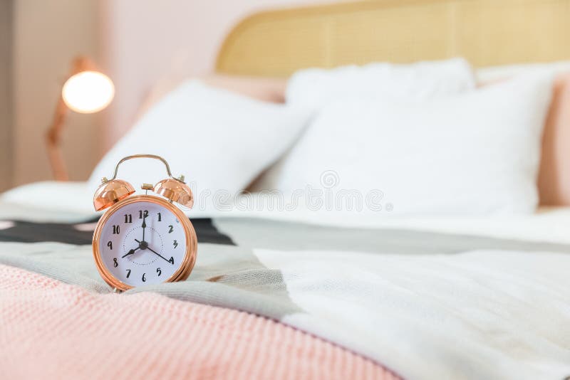 Classic alarm clock on bed stock photo. Image of countdown - 73306286